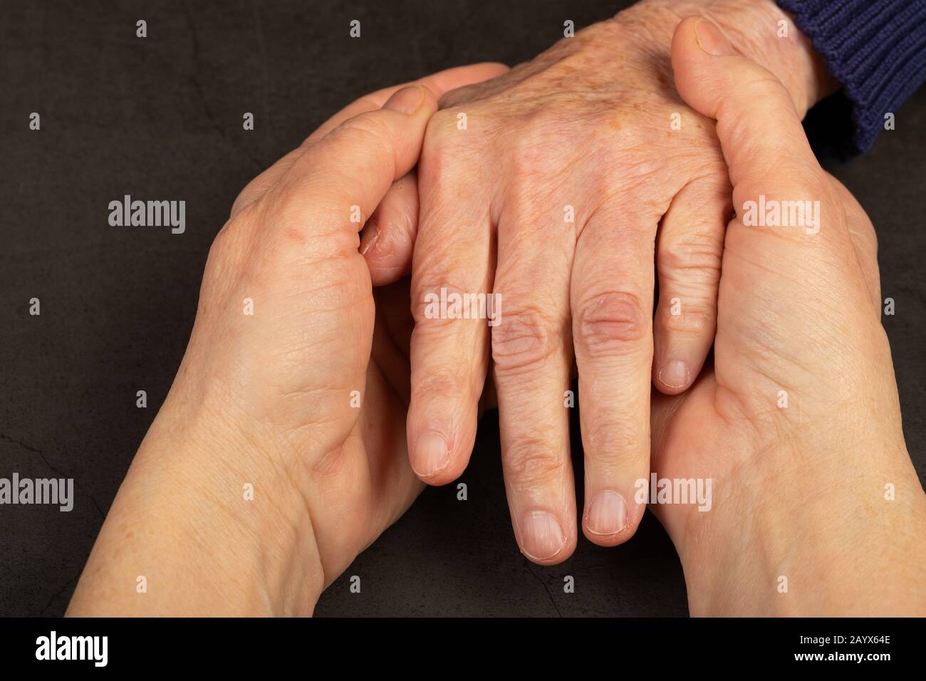 Caregiver touching elderly patients hand at home Stock Photo - Alamy