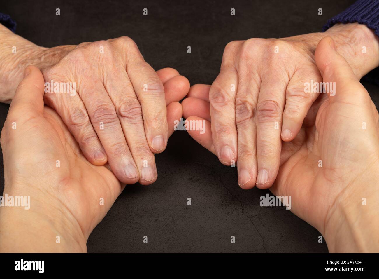 Caregiver touching elderly patients hand at home Stock Photo - Alamy