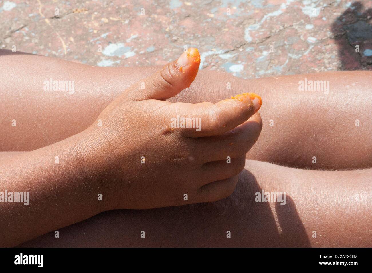 The hands of a young boy are covered with powder from junk food Stock ...