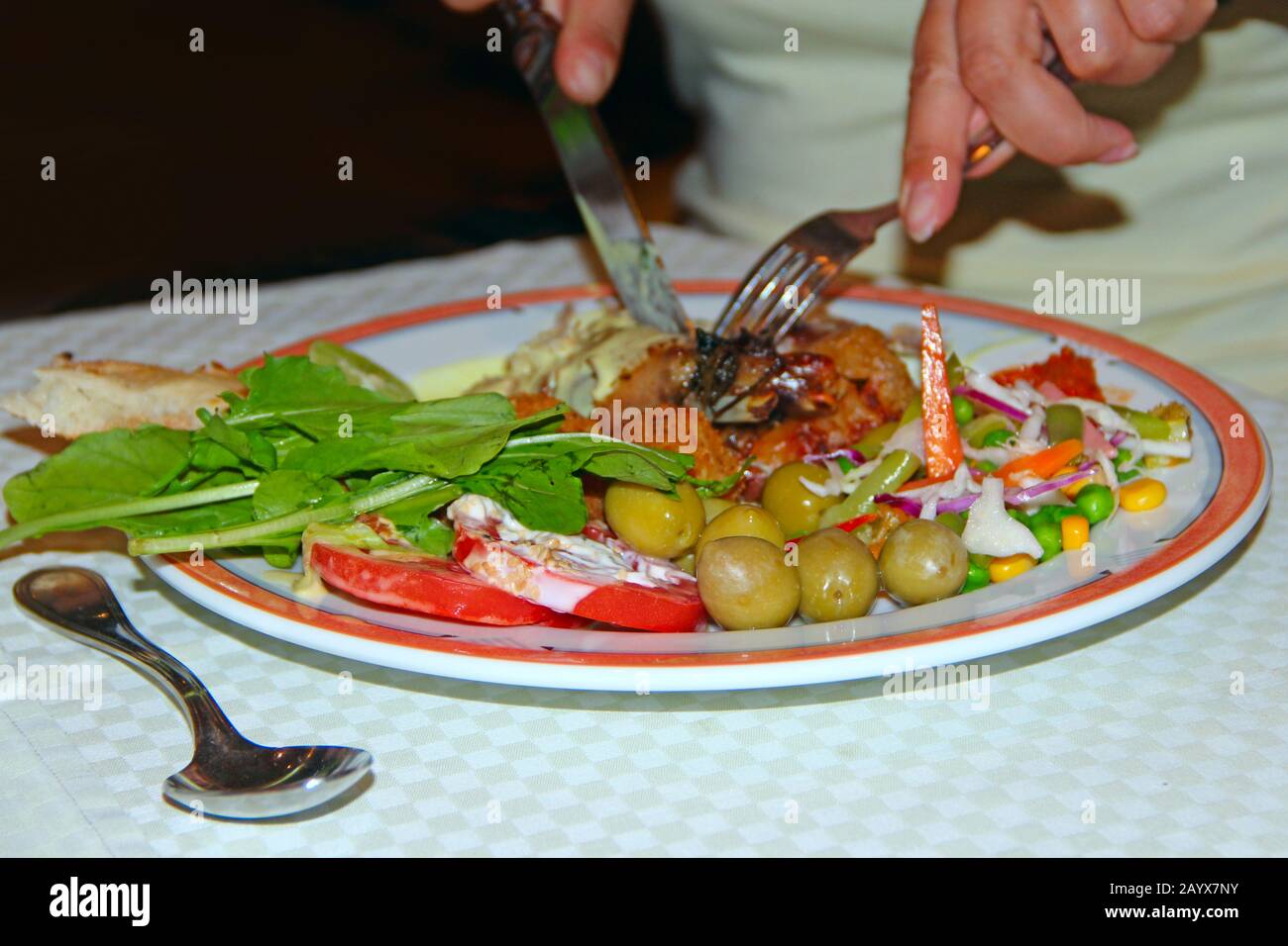 Human hands with fork and knife during eating dish with vegetables and ...