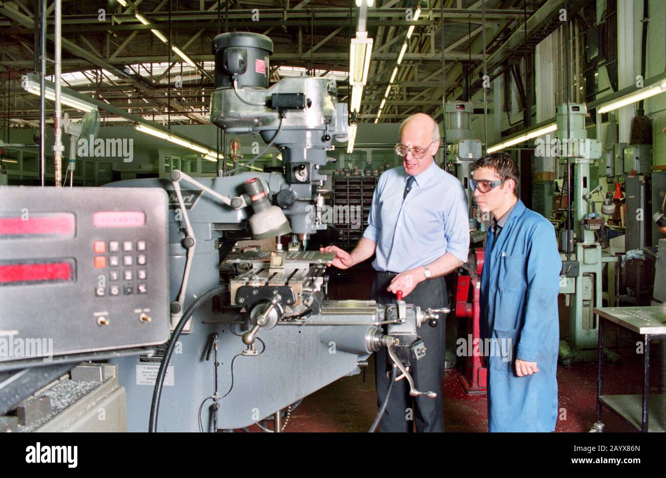modern apprentice being shown how to use the vertical milling machine ...