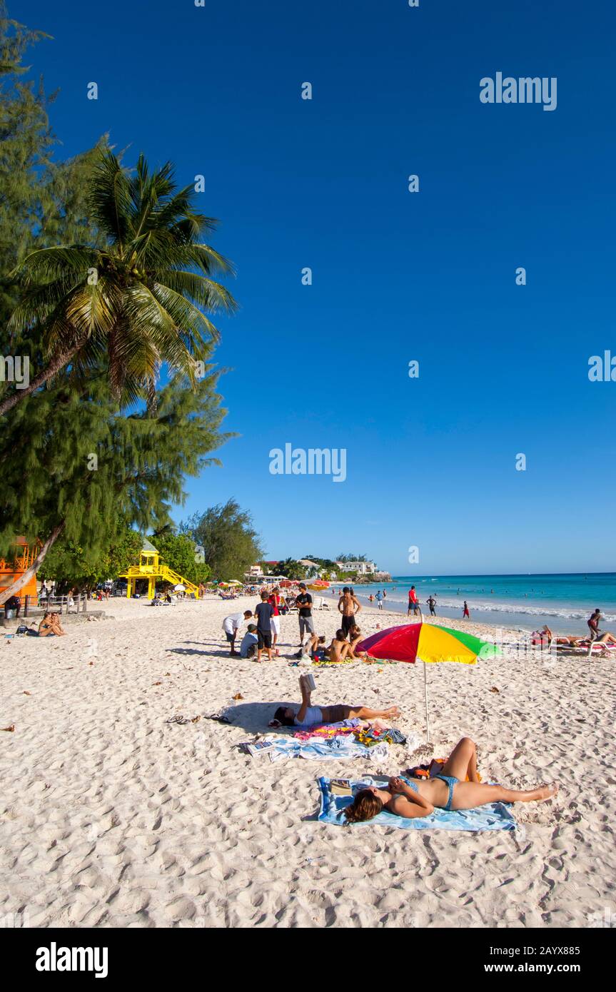 People sunbathing on a white sand beach at the southern coast of ...