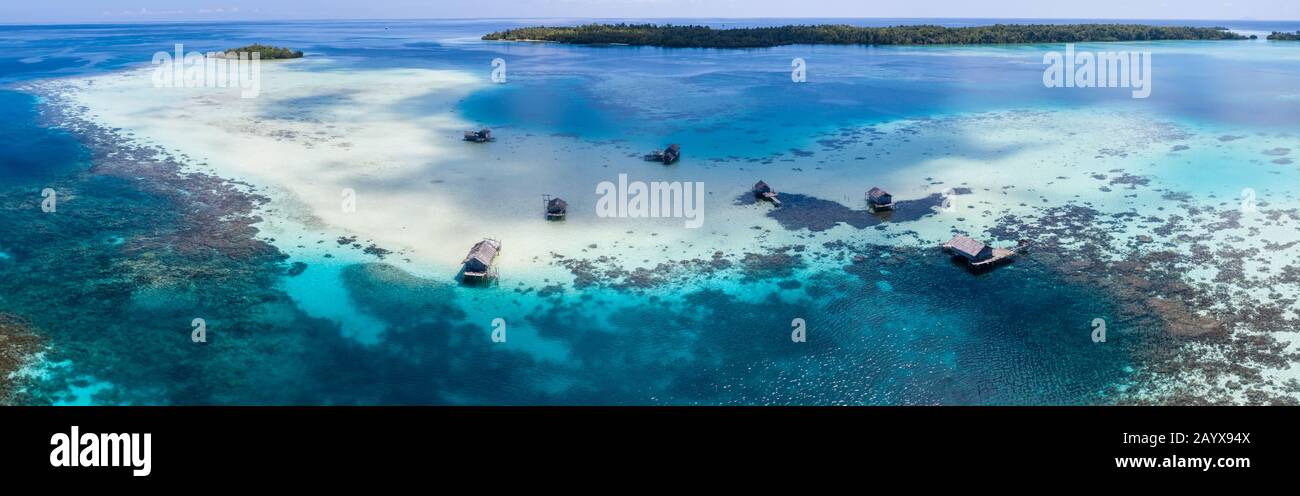 Fishing shacks are built on a remote reef in the Molucca Sea, Indonesia ...