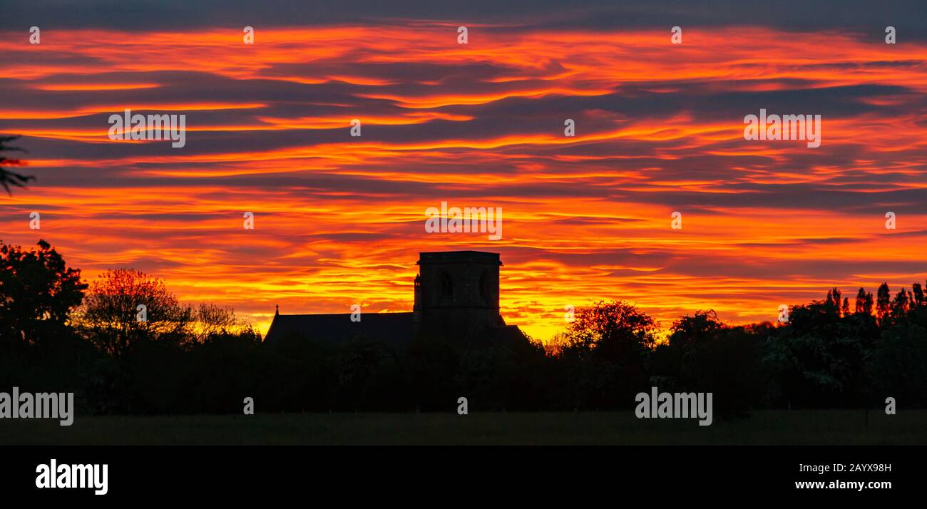 Sun going down behind a village church hi-res stock photography and ...