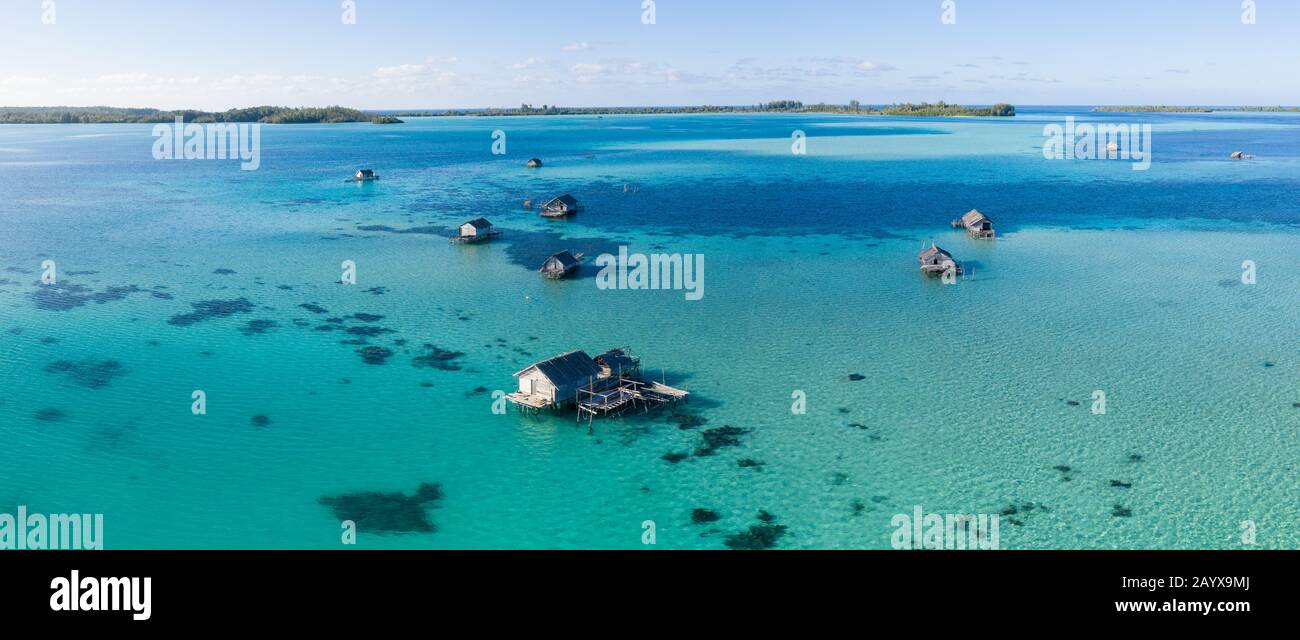 Fishing shacks are built on a remote reef in the Molucca Sea, Indonesia ...