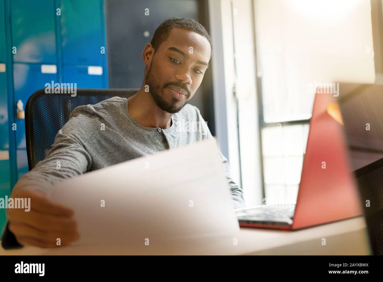 Attractive young black man working in modern office space Stock Photo ...