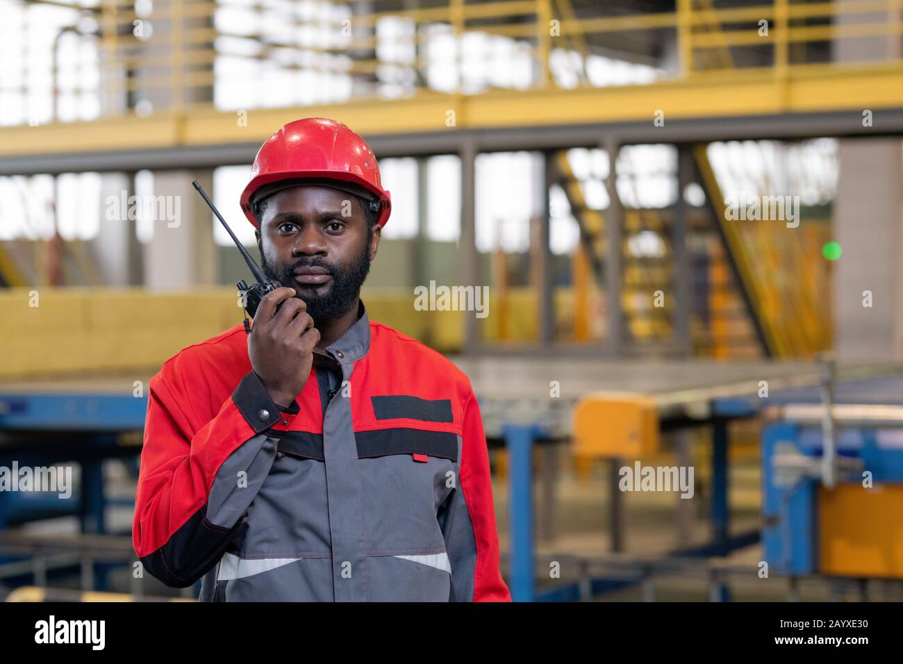 Horizontal portrait shot of professional factory worker using portable ...