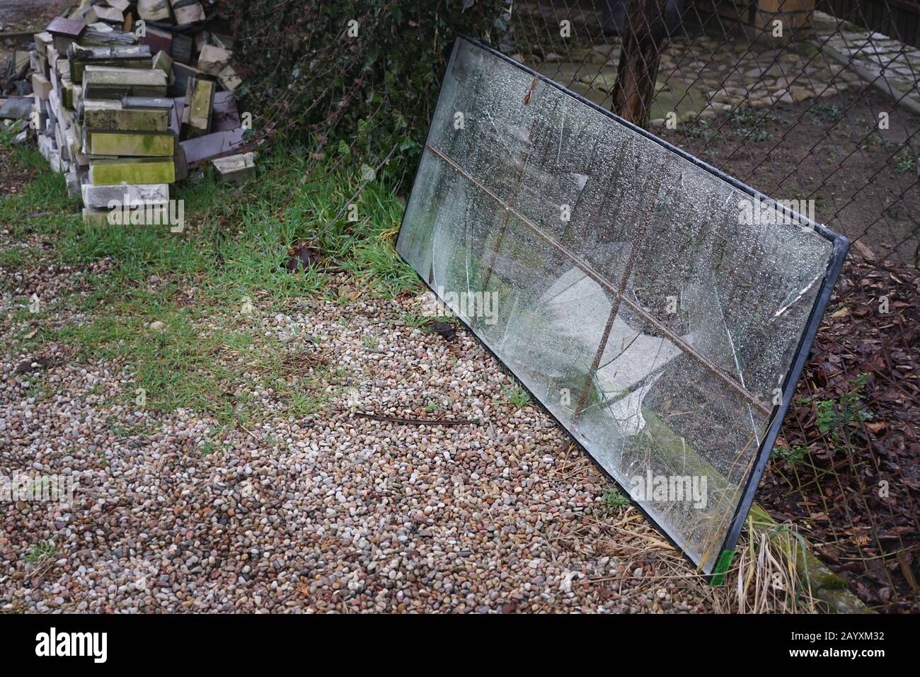 a broken, old window in the yard is waiting for waste disposal and ...