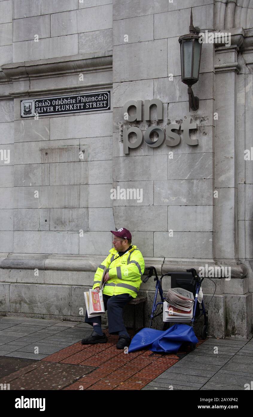 Traditional newspaper crier outside the Post Office on Oliver Plunkett ...