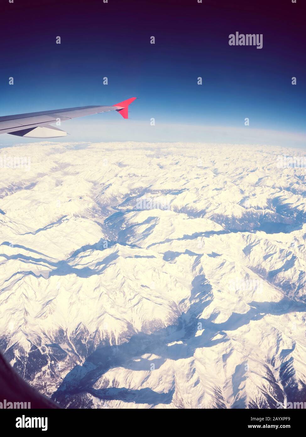 View of an airplane wing over snow capped sharp winter mountains Stock Photo - Alamy