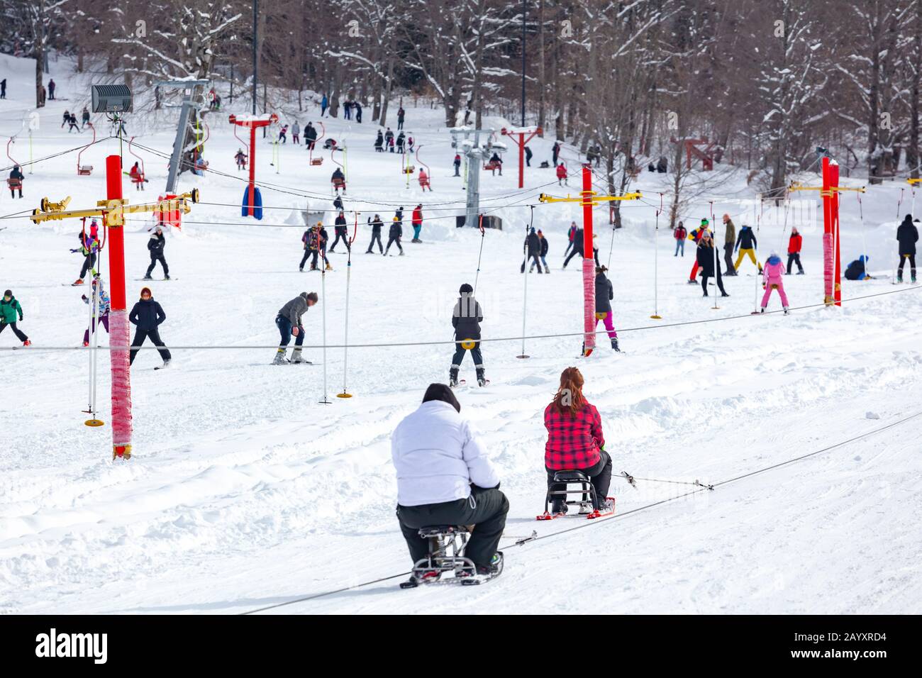 Skiers skiing climb a yoke on a mountain. Light skiing track in ...