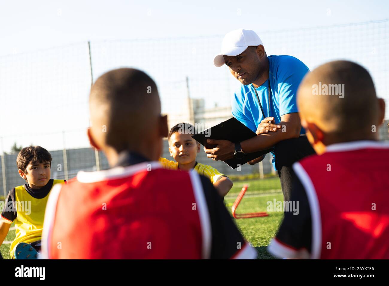Soccer players listening to their coach Stock Photo - Alamy