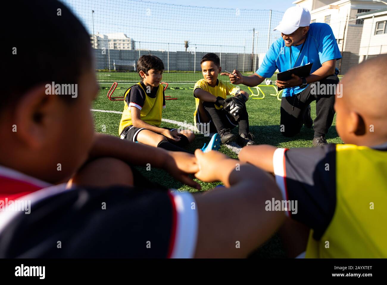 Soccer players listening to their coach Stock Photo - Alamy