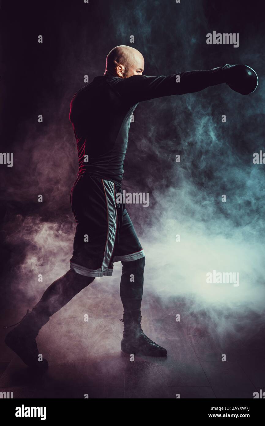 Sportsman boxer fighting on black background with smoke. Boxing sport ...