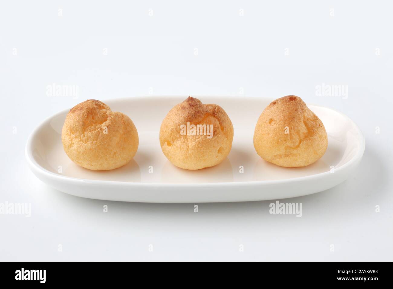 cream puffs on plate closeup isolated on white background Stock Photo ...