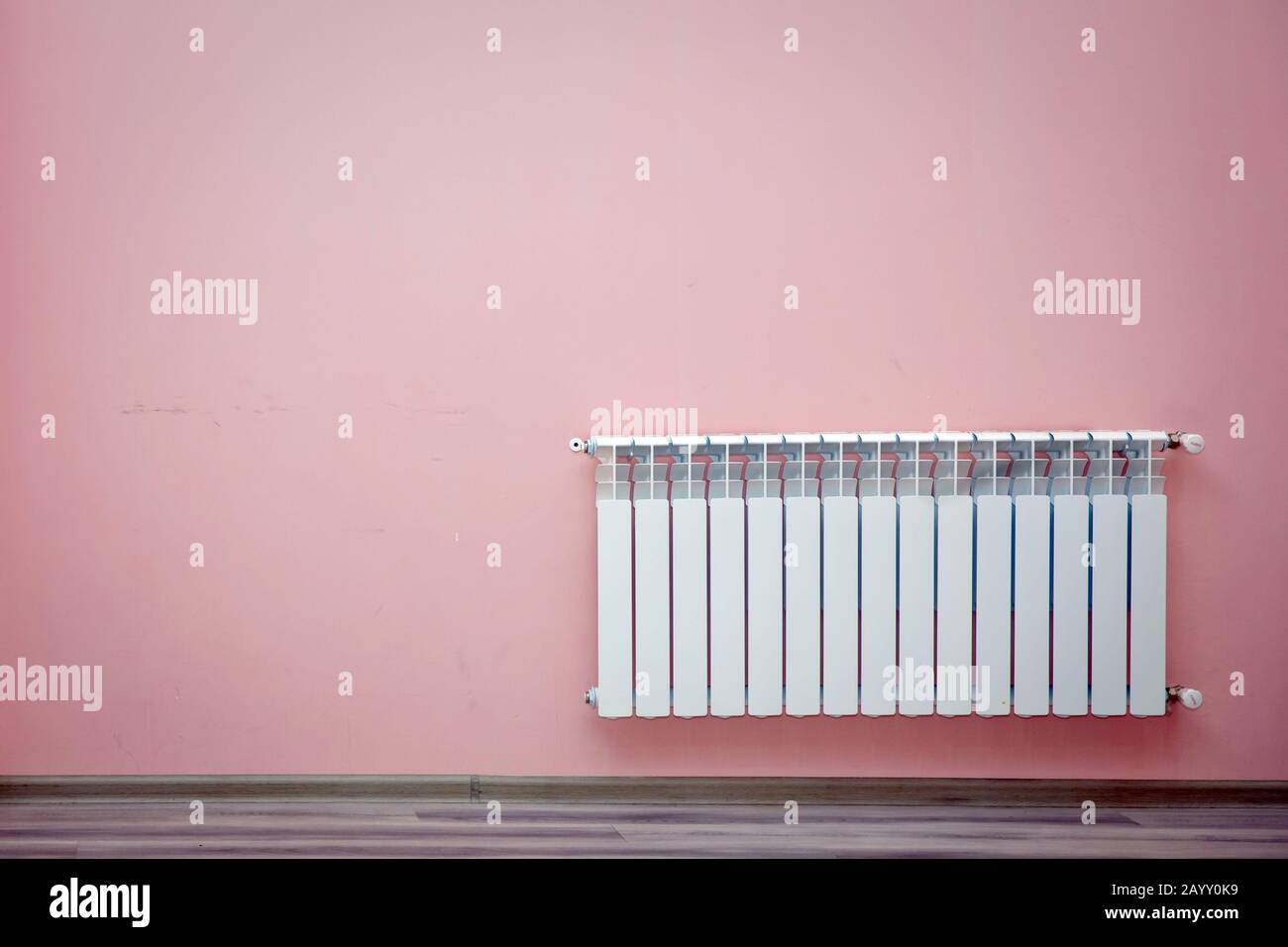 home gas heater closeup .Heating radiator on a pink wall at an ...