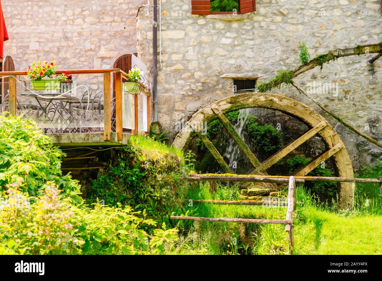 view of old stone building with shutter on windows and water mill Stock ...