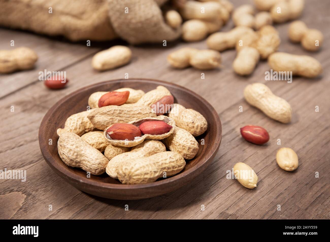 Peanuts in bowl on rustic wooden table. Arachis hypogaea Stock Photo - Alamy