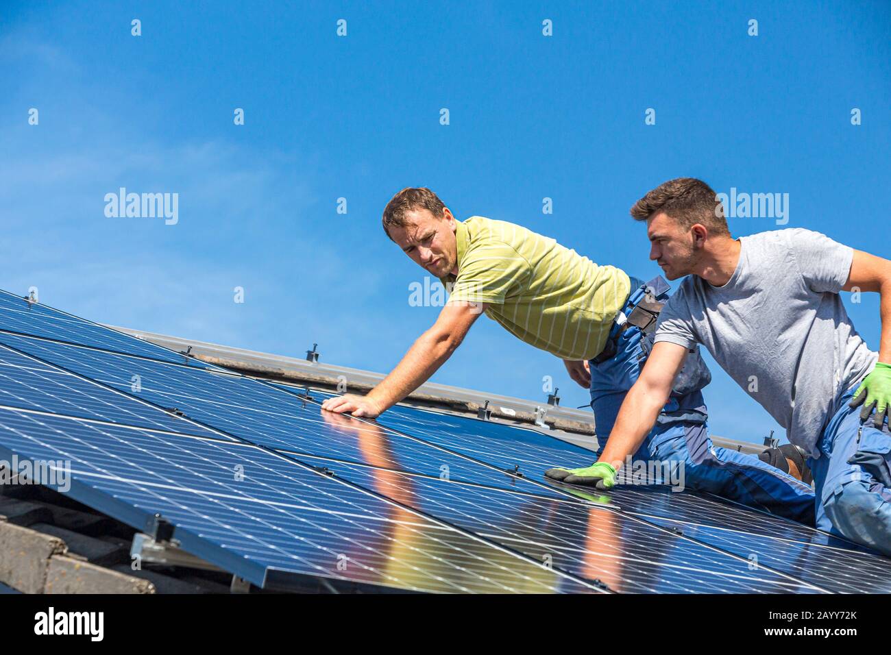 Installing solar photovoltaic panel system. Solar panel technician installing solar panels on ...