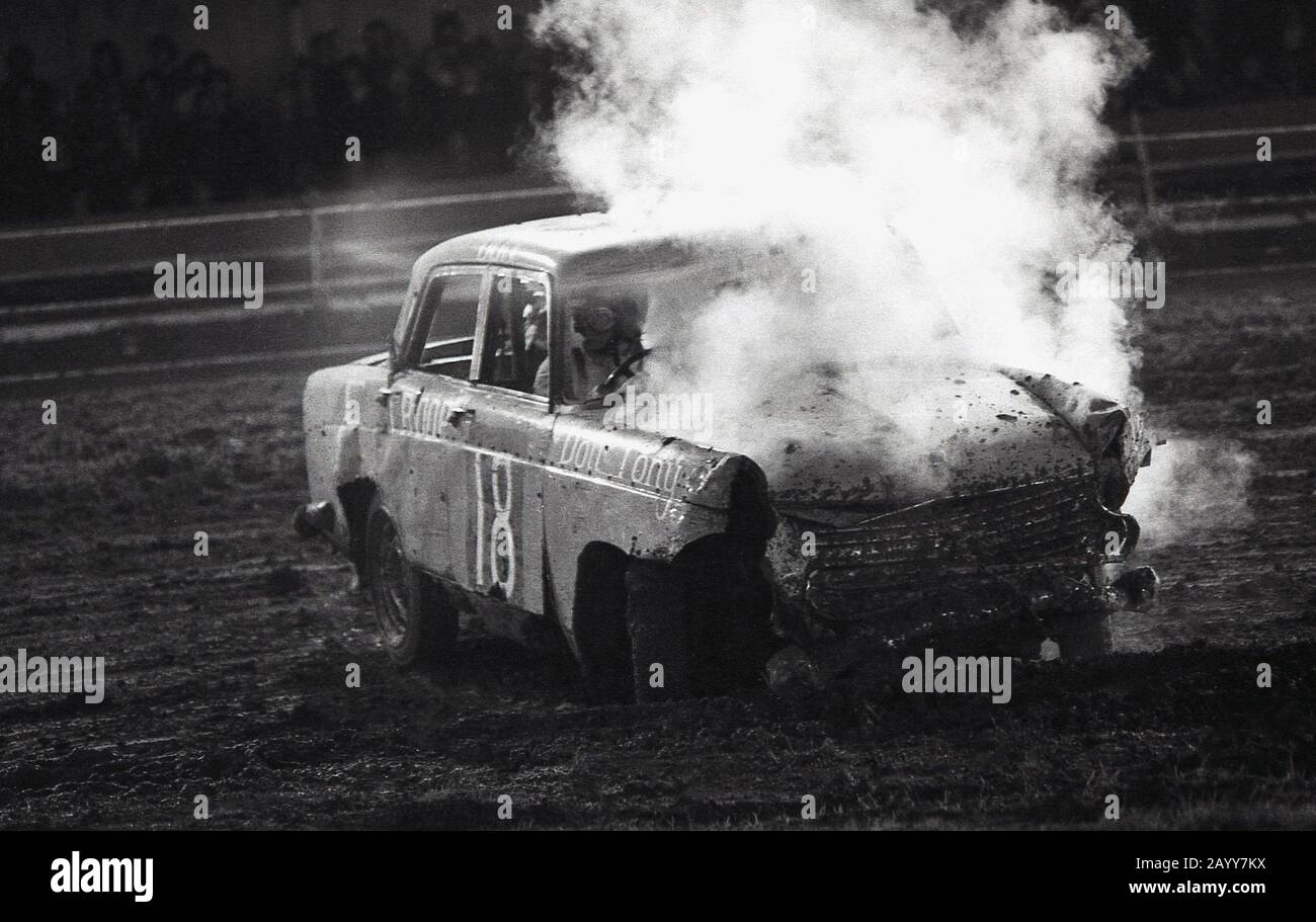 1970s, historical, a banger racing car with smoke pouring out from a ...