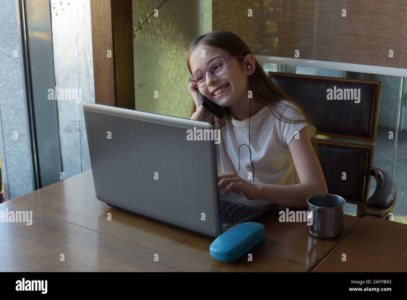Young charming female using laptop computer while sitting in modern ...