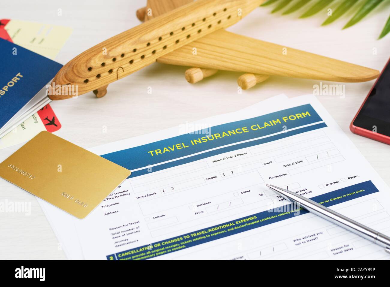 Travel insurance claim form with a boarding pass and passport on white ...