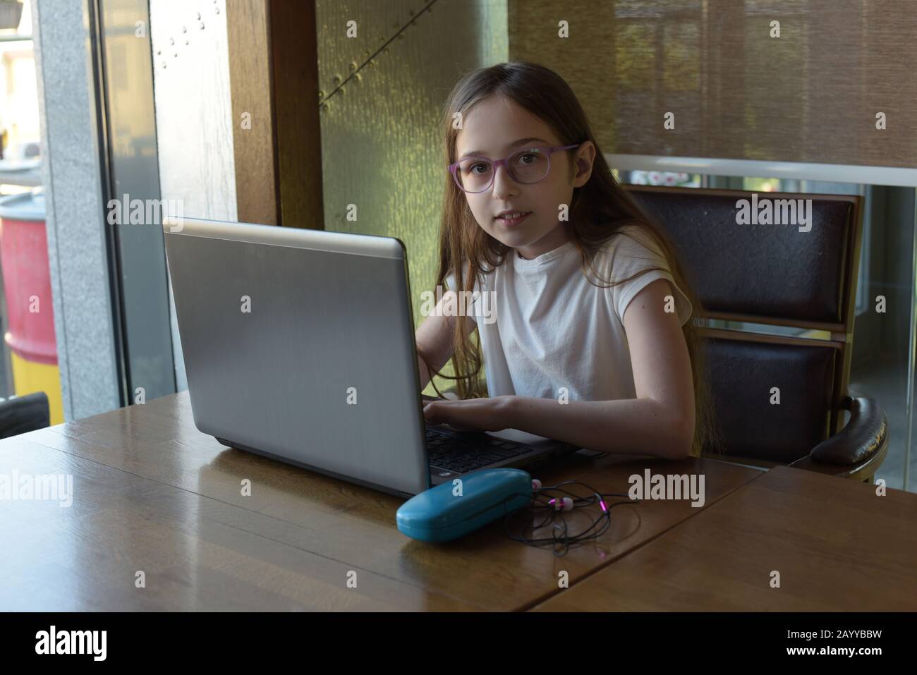 Young charming female using laptop computer while sitting in modern ...
