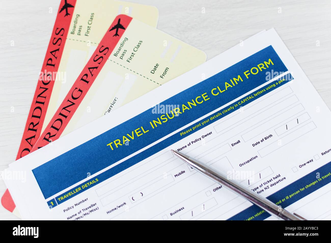 Travel insurance claim form with a boarding pass and passport on white ...