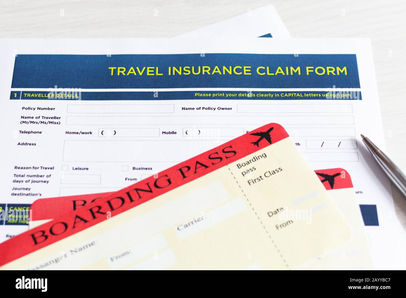 Travel insurance claim form with a boarding pass and passport on white ...