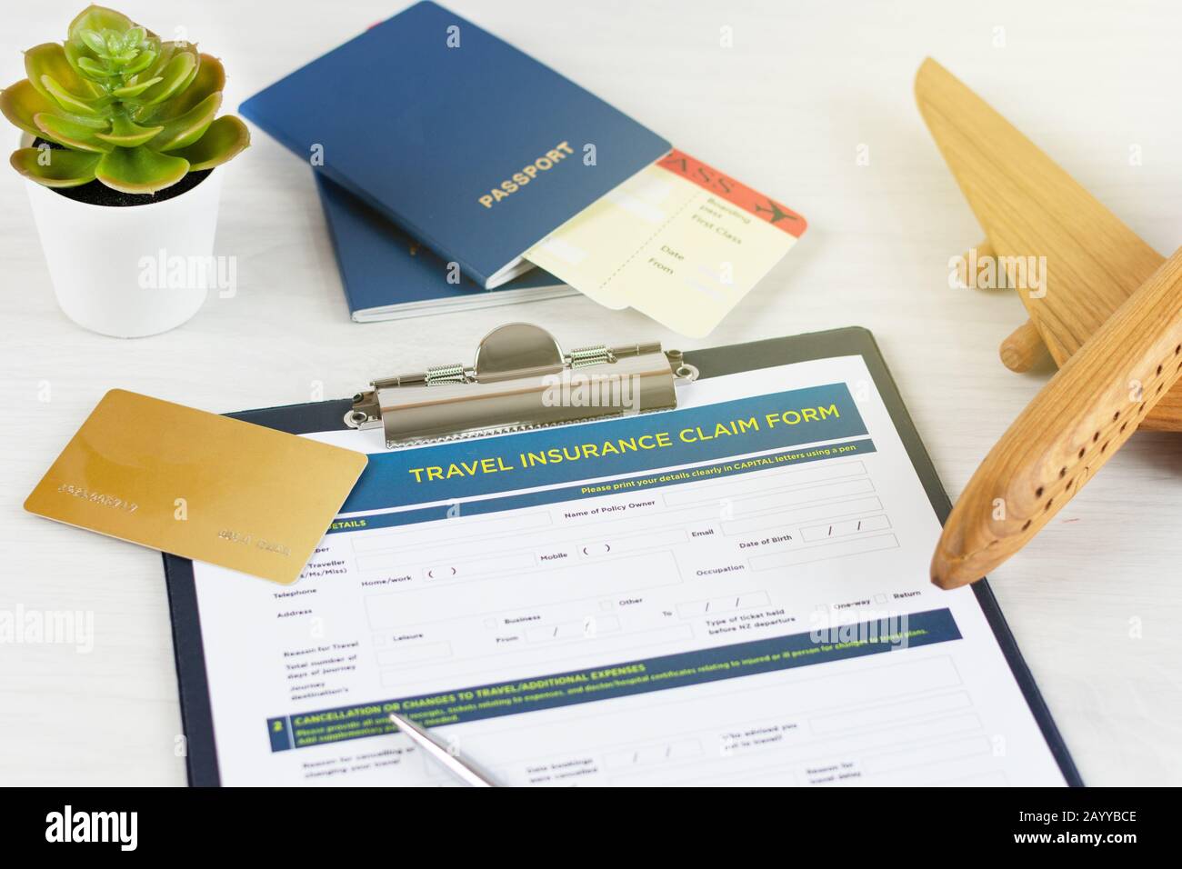 Travel insurance claim form with a boarding pass and passport on white ...