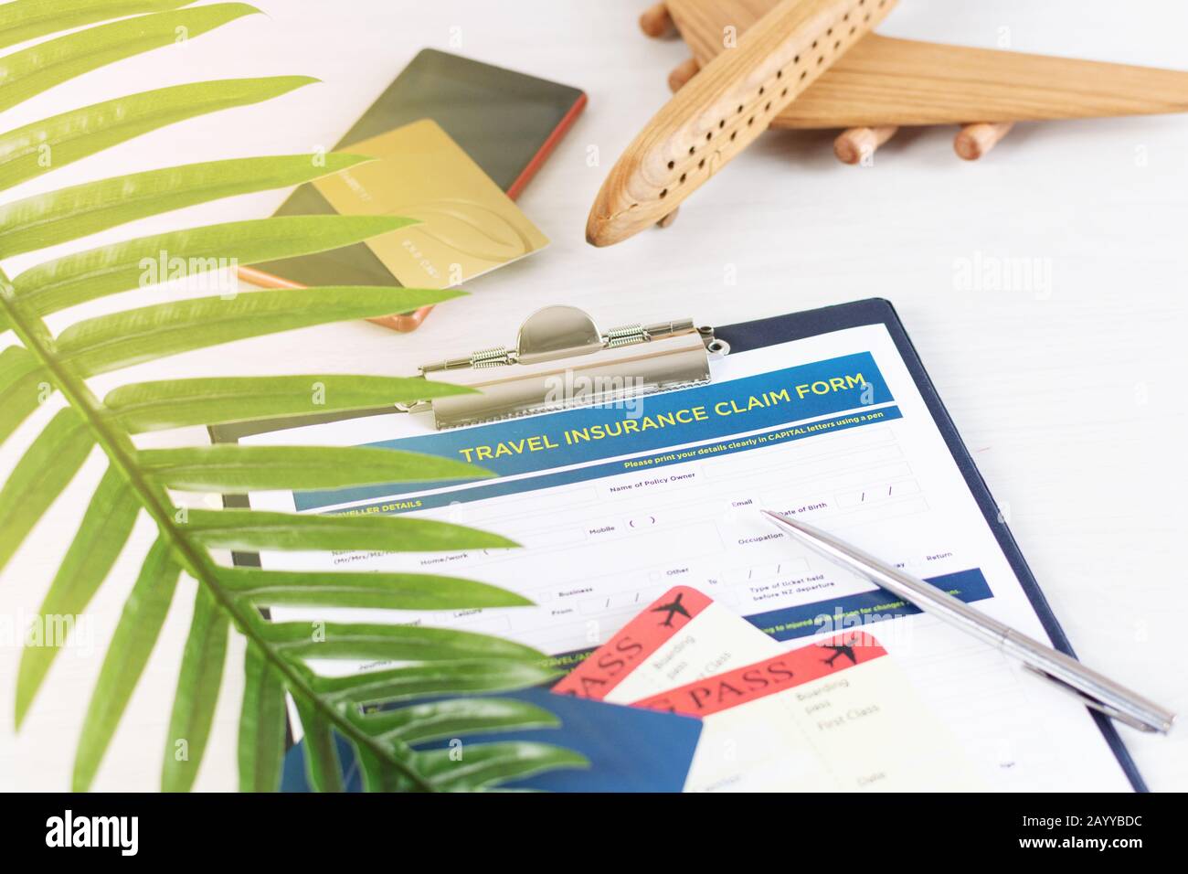 Travel insurance claim form with a boarding pass and passport on white ...