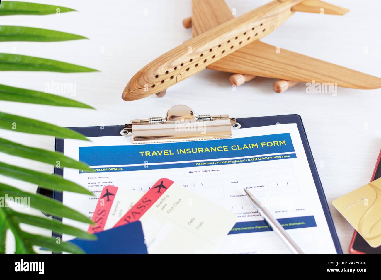 Travel insurance claim form with a boarding pass and passport on white ...