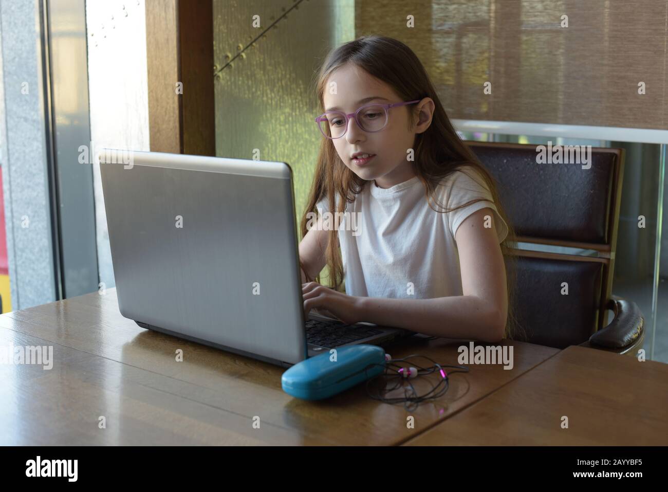 Young charming female using laptop computer while sitting in modern ...