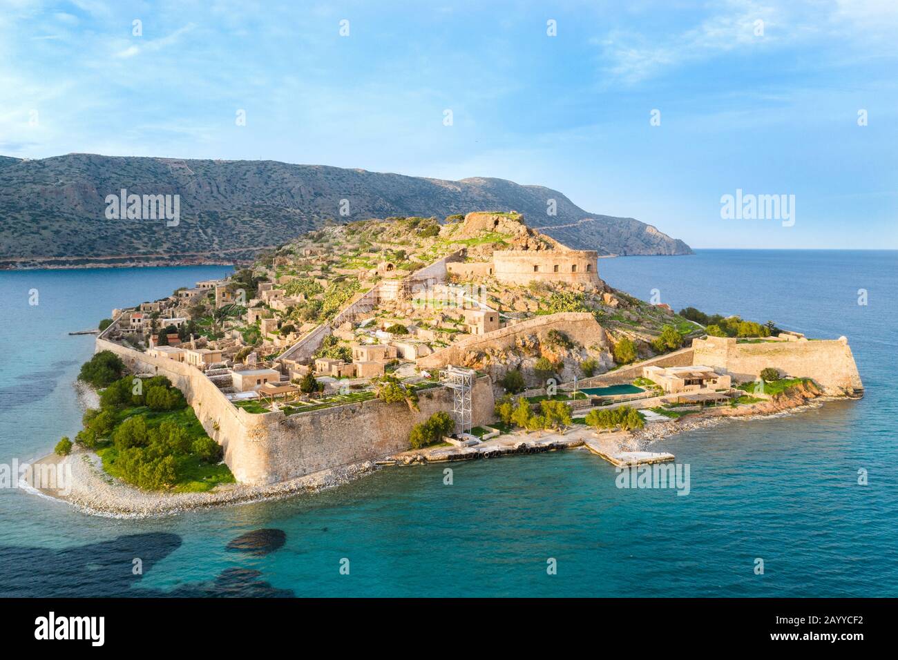 Aerial view of the island of Spinalonga with calm sea. Here were ...