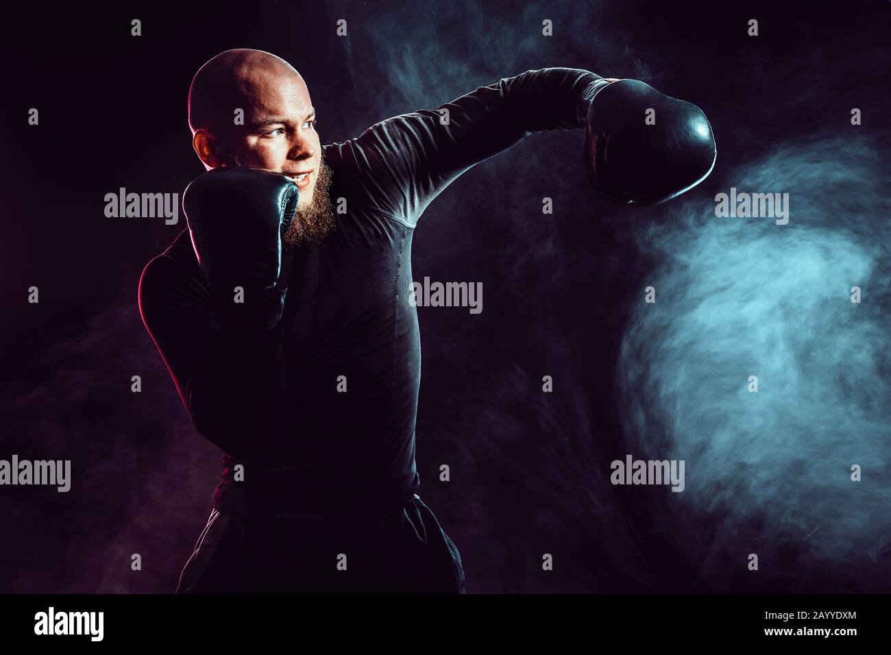 Sportsman boxer fighting, hitting side impact on black background with ...