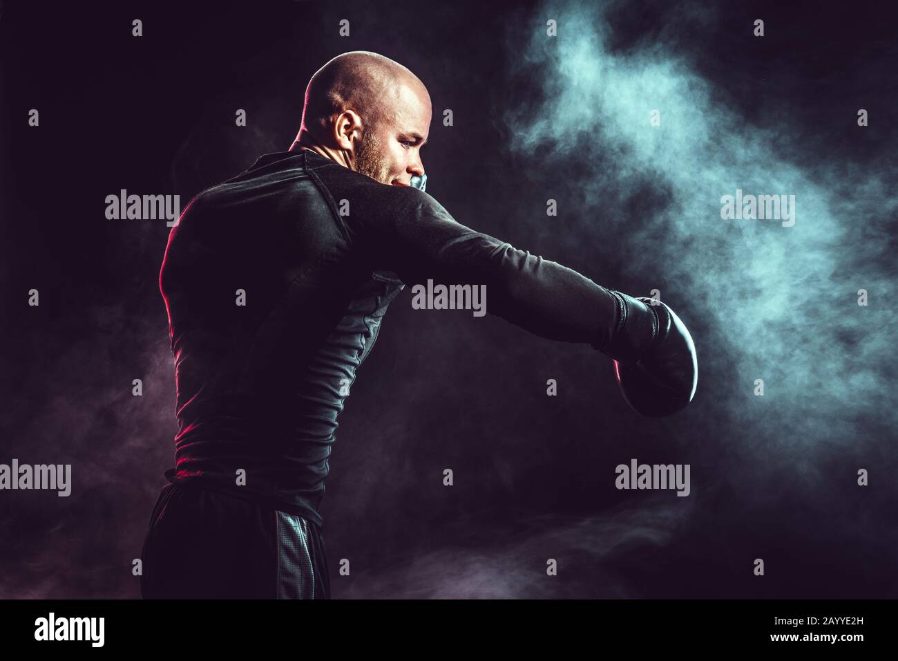 Sportsman boxer fighting, hitting side impact on black background with ...
