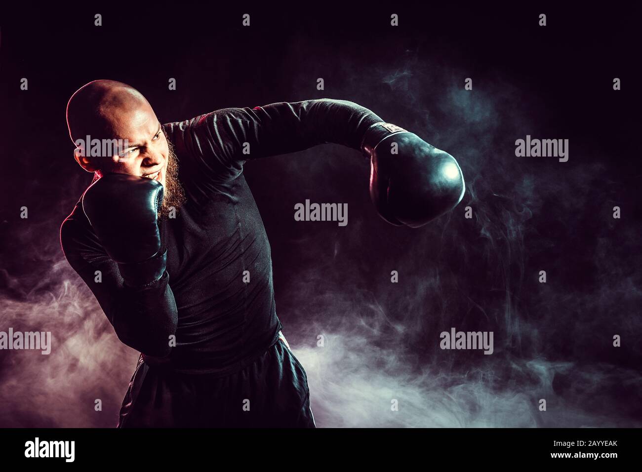 Sportsman boxer fighting, hitting side impact on black background with ...