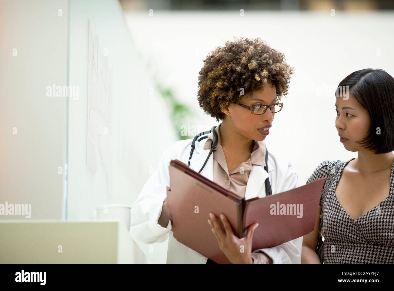 Female doctor talking to patient Stock Photo - Alamy