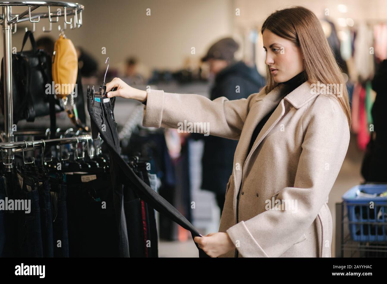Young beautiful woman looking for new jeans in clothing store Stock ...