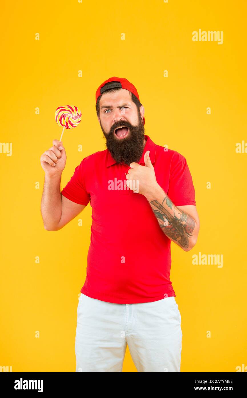 Happy eating sweets. Man show thumb up. Holiday concept. Sugar harmful ...