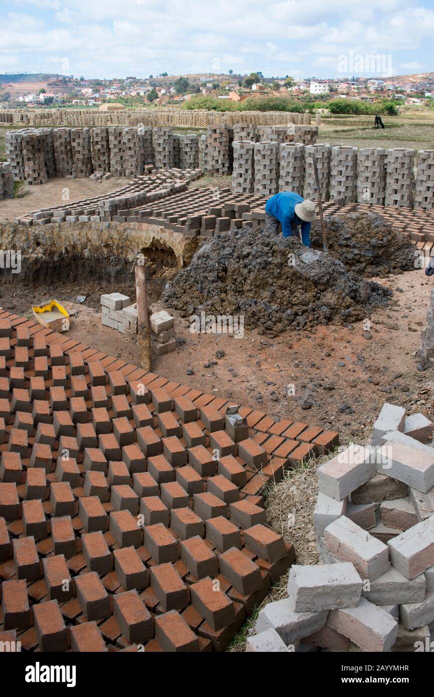 Man mixing clay for brick macking on the outskirts of Antananarivo, the ...