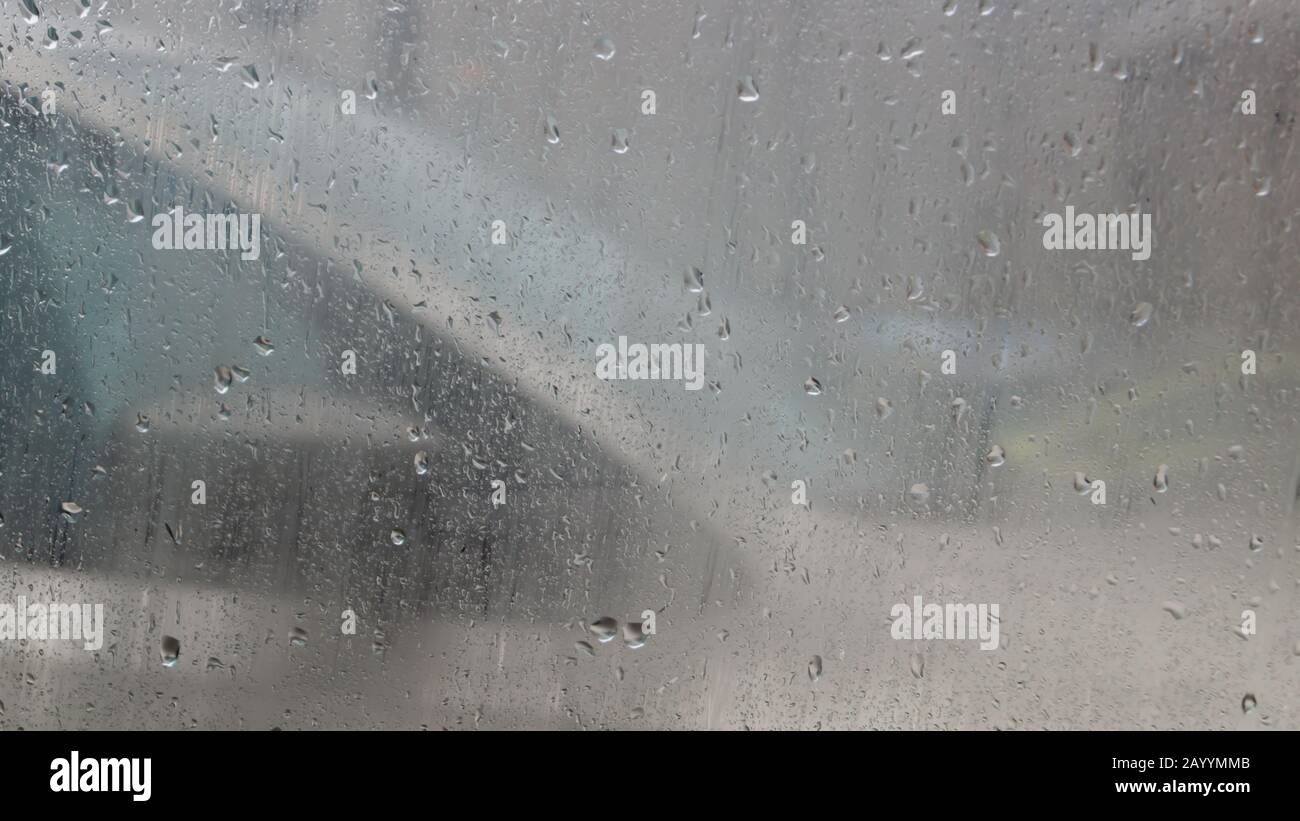 Rain falls on the car window. view on the car through the glass with ...