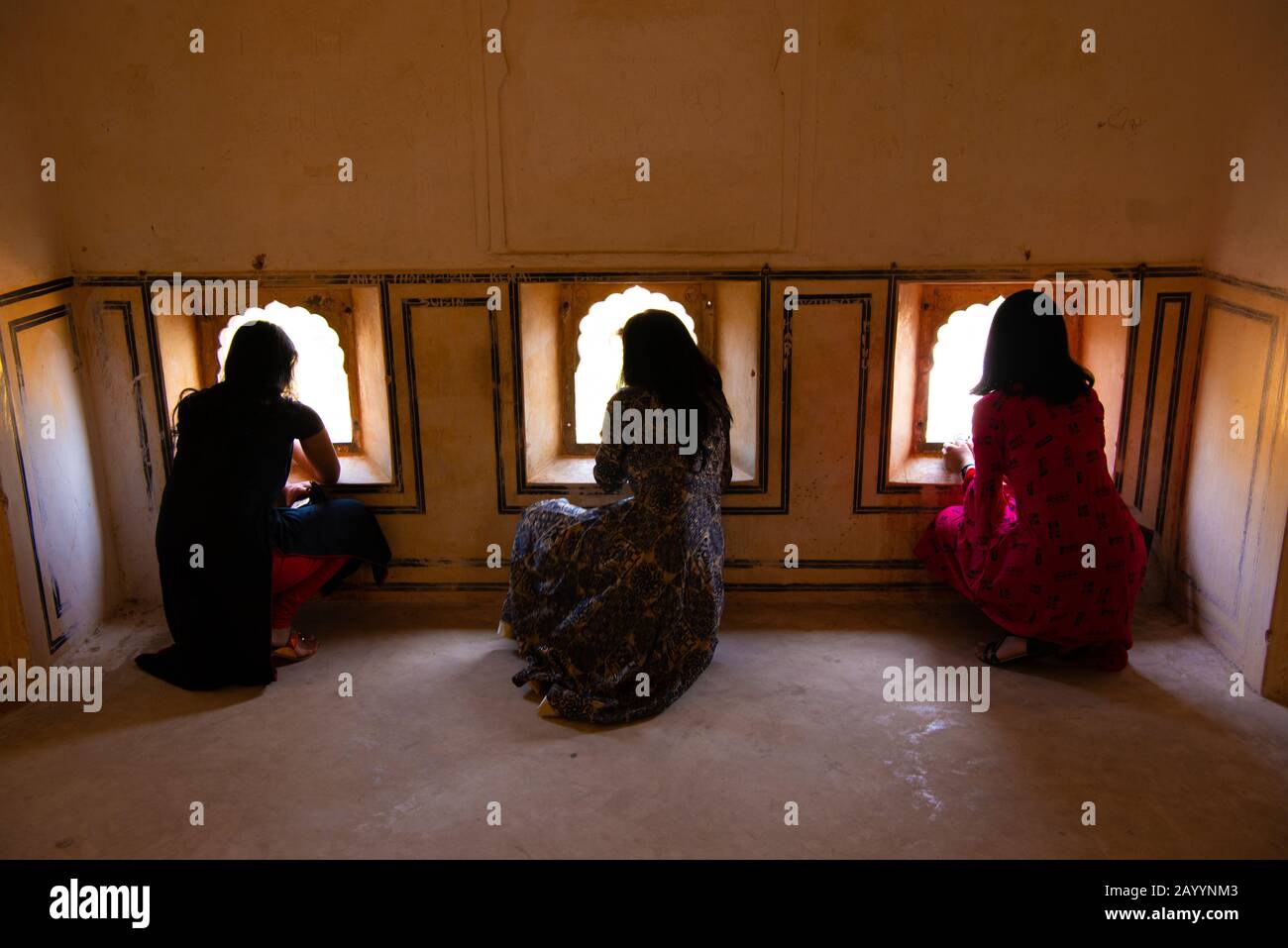 Visitors and tourists look out windows as they explore the ancient ...