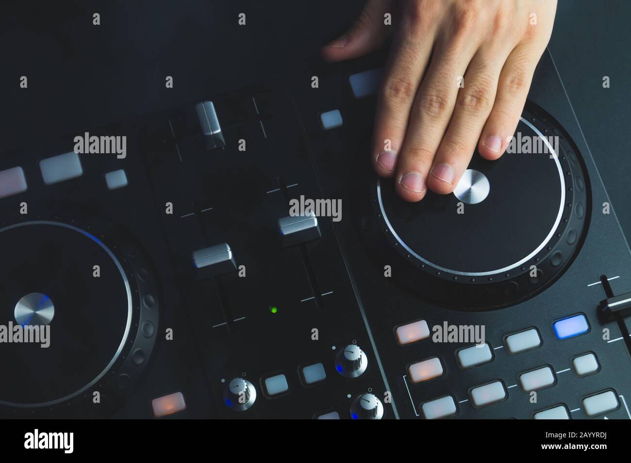 DJ plays music. sound mixer controller with knobs and sliders close up ...