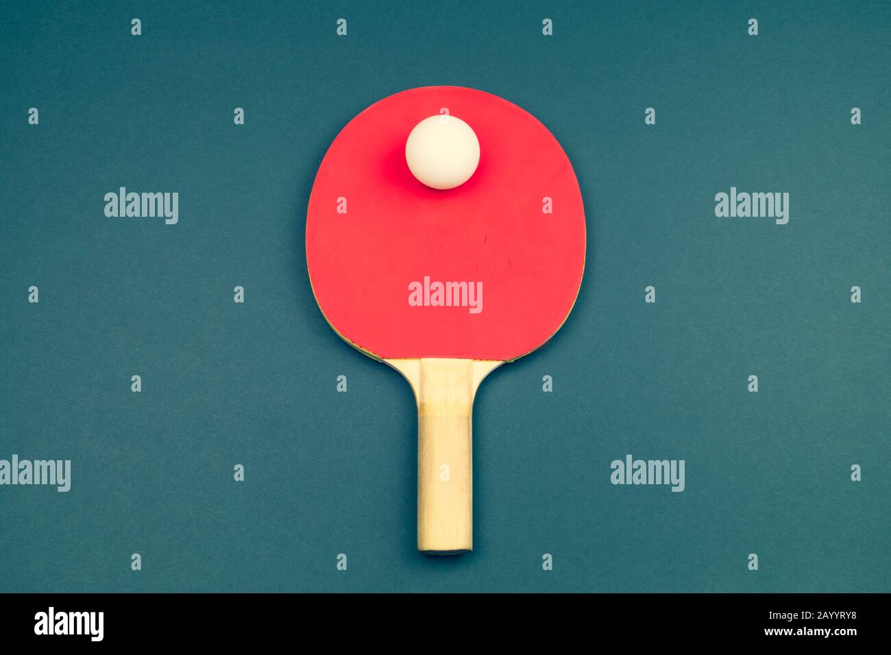 Red table tennis racket with a ball isolated on a colored background ...