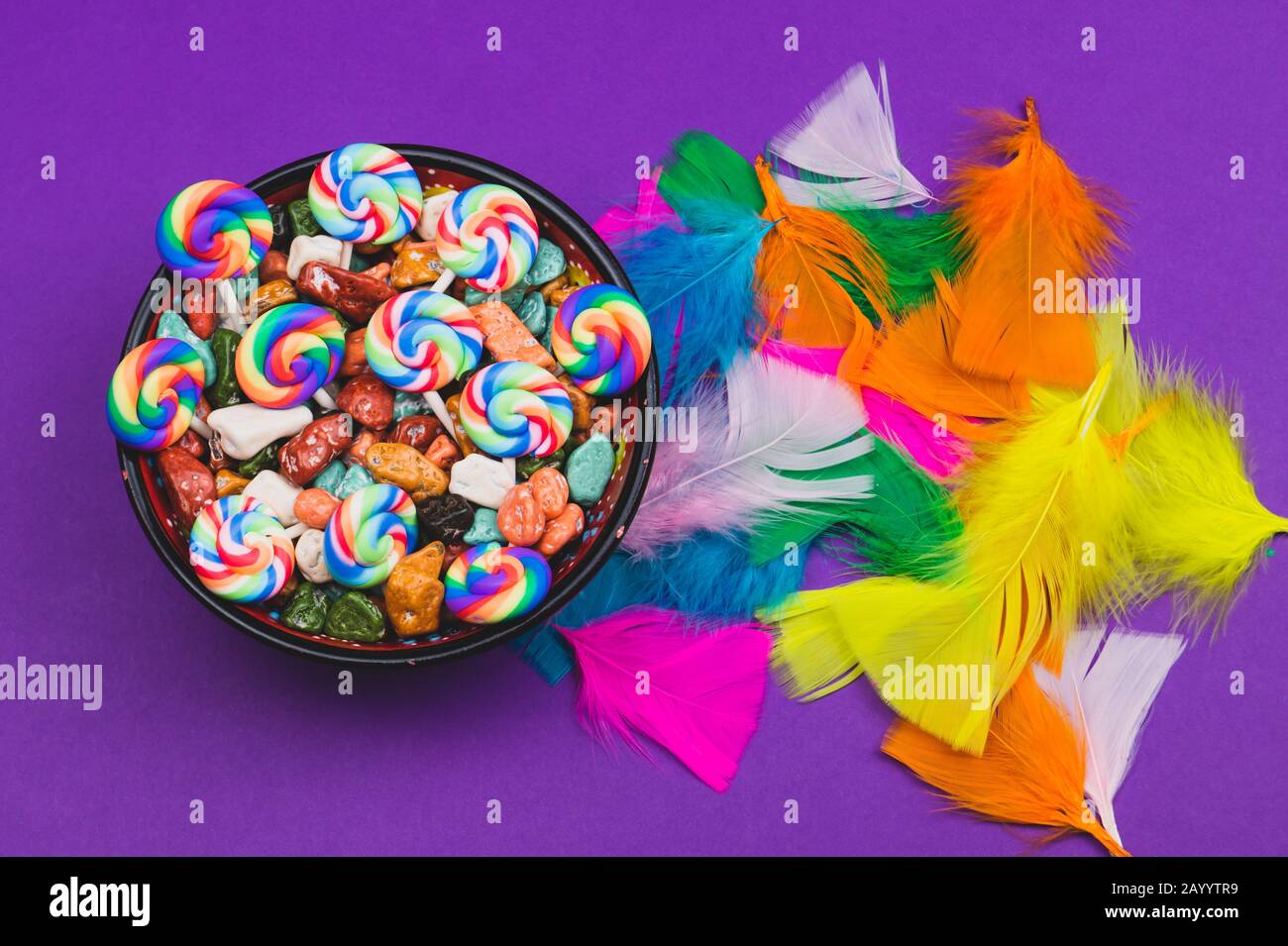 Candy pebbles in a bowl and lollipops. spiral candies and sweets in the ...
