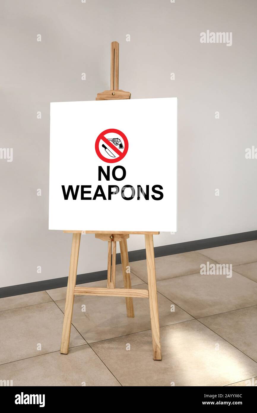 This is a no weapons sign placed on a board in front of the restaurant ...