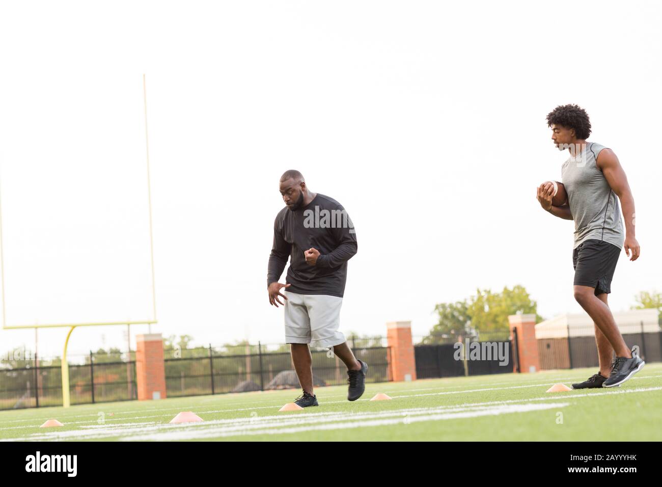 American Football coach training a young athlete Stock Photo - Alamy