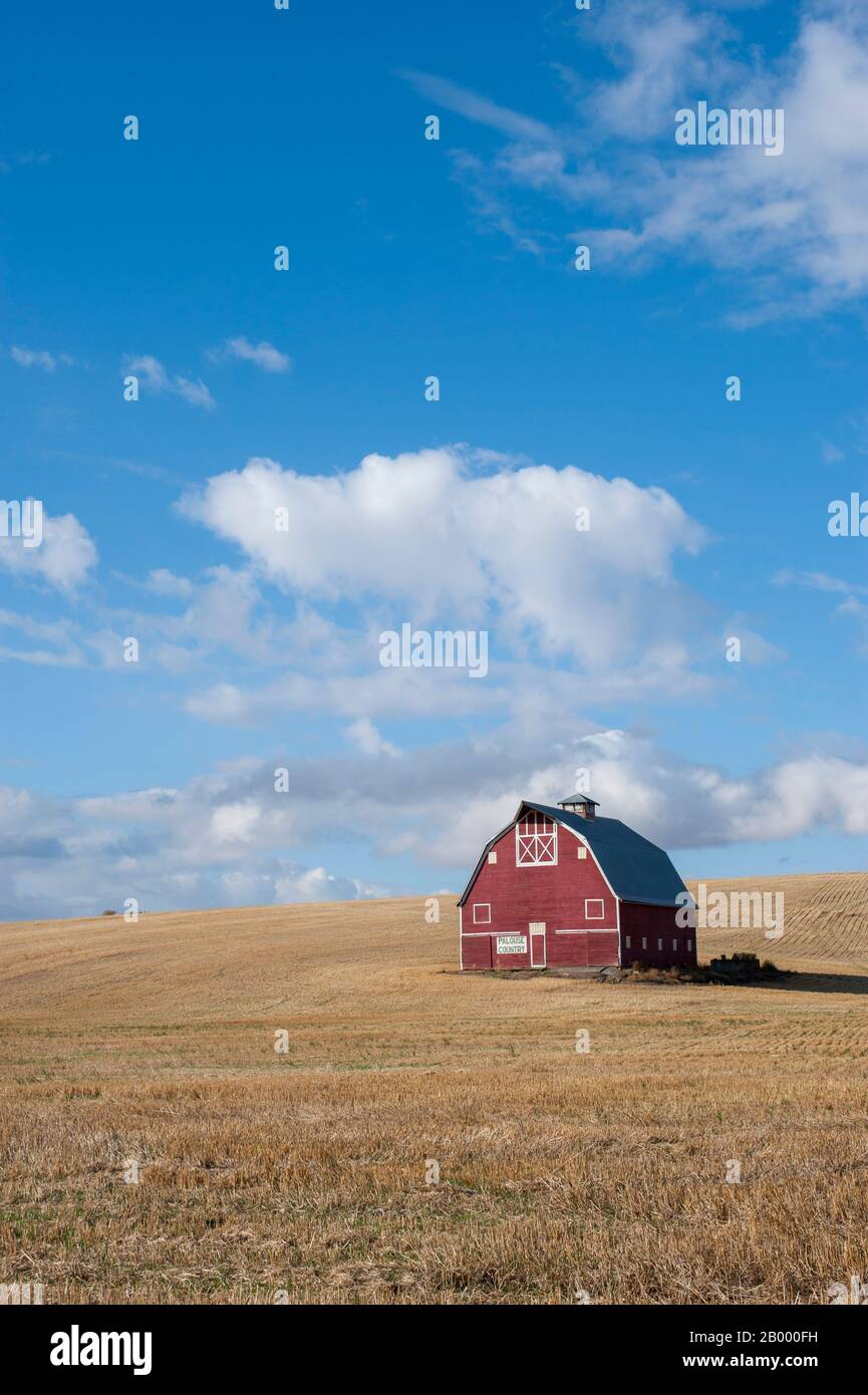 Clouds over a harvested wheat field and a red barn (Palouse Barn) in ...