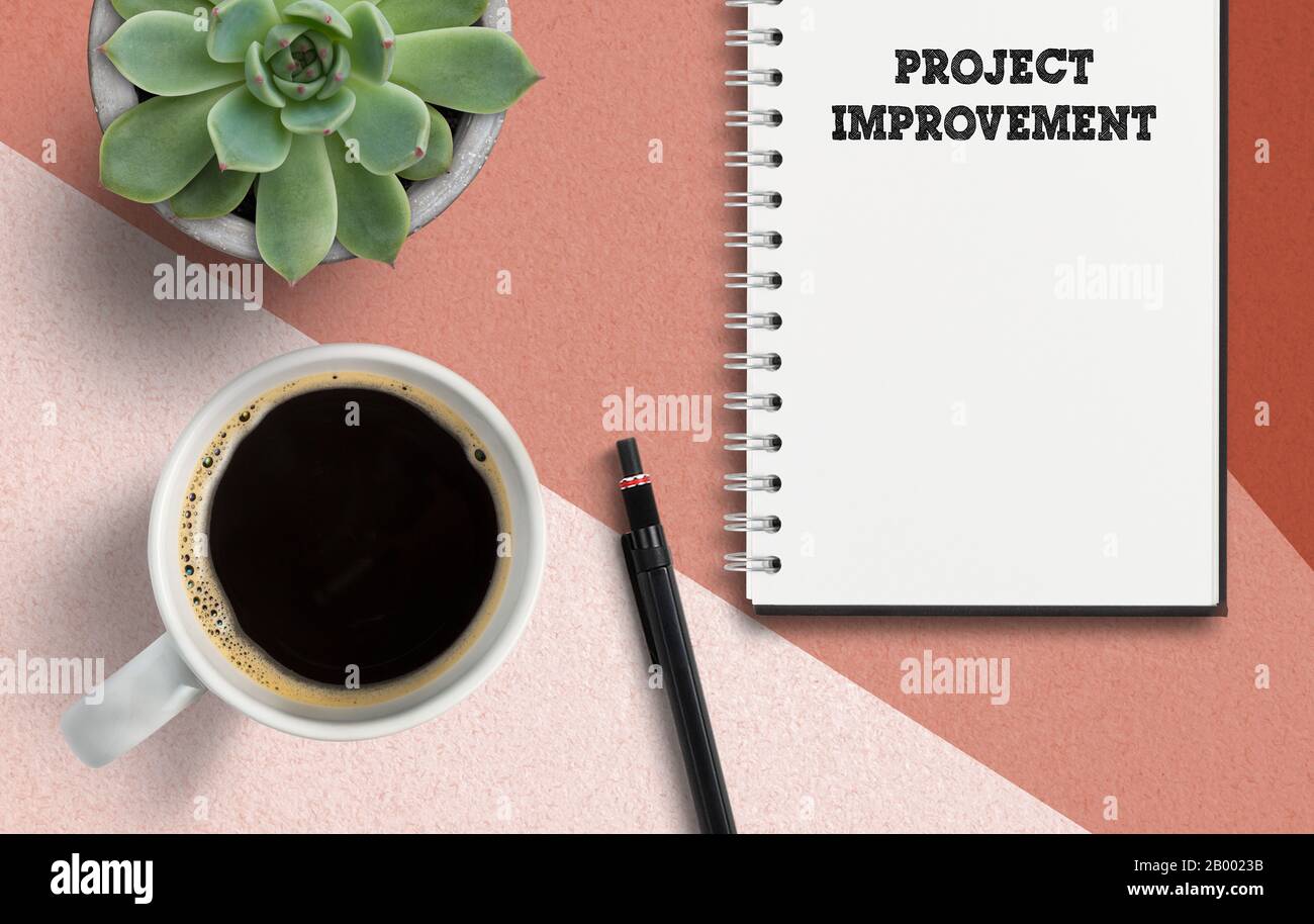 notebook with message "project improvement" on paper background with ...
